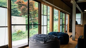 Quarto com janelas amplas, piso de madeira e dois sacos de feijão.