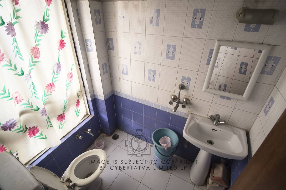 Uma casa de banho com sanita, lavatório e espelho.
