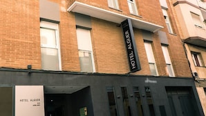 Um edifício de hotel moderno com uma placa de destaque que diz 'HOTEL ALGUER'.