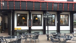 Um restaurante chamado "Landhaus Brockenblick" com área externa e uma placa anunciando um café da manhã especial.