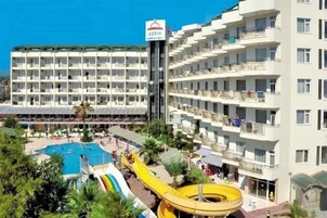 Um hotel com vários andares, piscina e um toboágua.