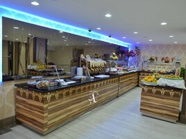 Buffet com diversos alimentos e um espelho decorativo.