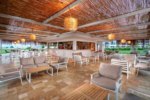 Ampla área externa com assentos, um bar, móveis modernos e vista para a paisagem.