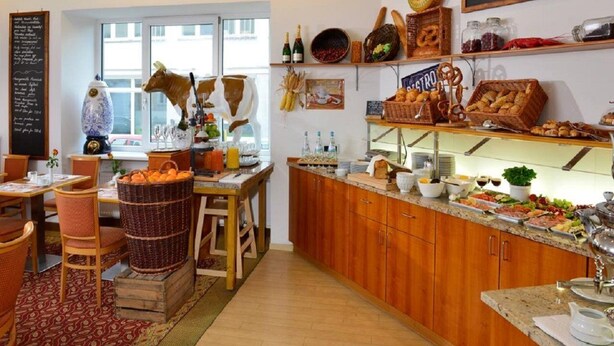 Um restaurante acolhedor com armários de madeira, um balcão de buffet com diversos alimentos e um cardápio em lousa.