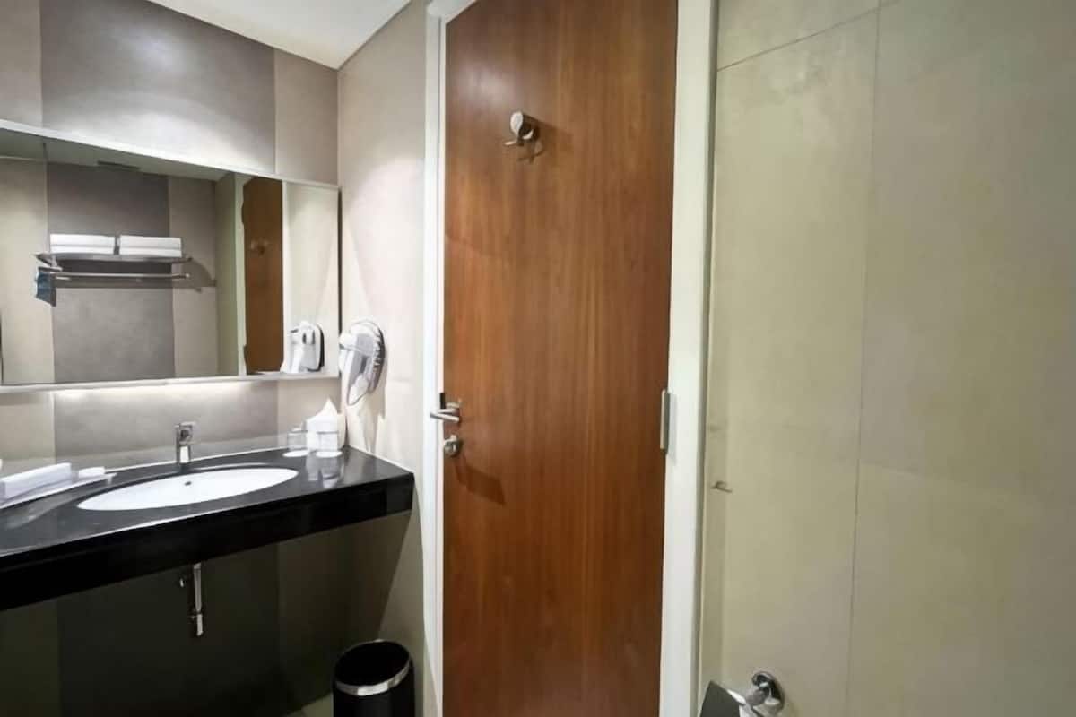 Casa de banho | Uma combinação polibã/banheira, um chuveiro fixo, chinelos, um bidé