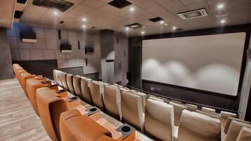 Um cinema moderno com fileiras de assentos de couro, uma tela grande e um sistema de som.