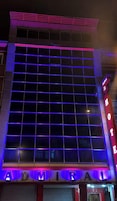 Um edifício com uma grande fachada de vidro e a palavra 'ADMIRAL' iluminada no andar térreo.