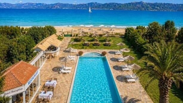 Um hotel com piscina, área de estar externa e vista para o mar.