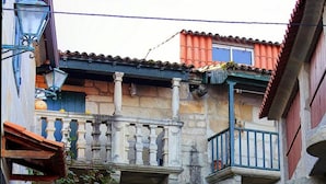 Uma escadaria de pedra que leva a um edifício com varanda.