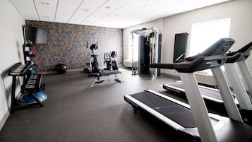 Academia com esteiras, elípticos e equipamentos de musculação.