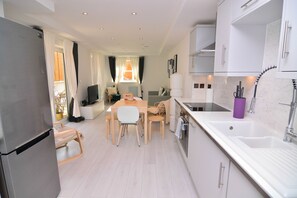 Apartamento luxo, 2 quartos, varanda | Cozinha privada | Geladeira grande, micro-ondas, fogão, cooktop