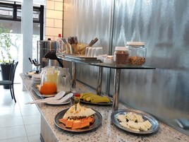 Um buffet de café da manhã com diversos alimentos e acompanhamentos.