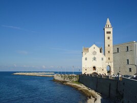 Um edifício costeiro com uma torre imponente e um grande relógio.