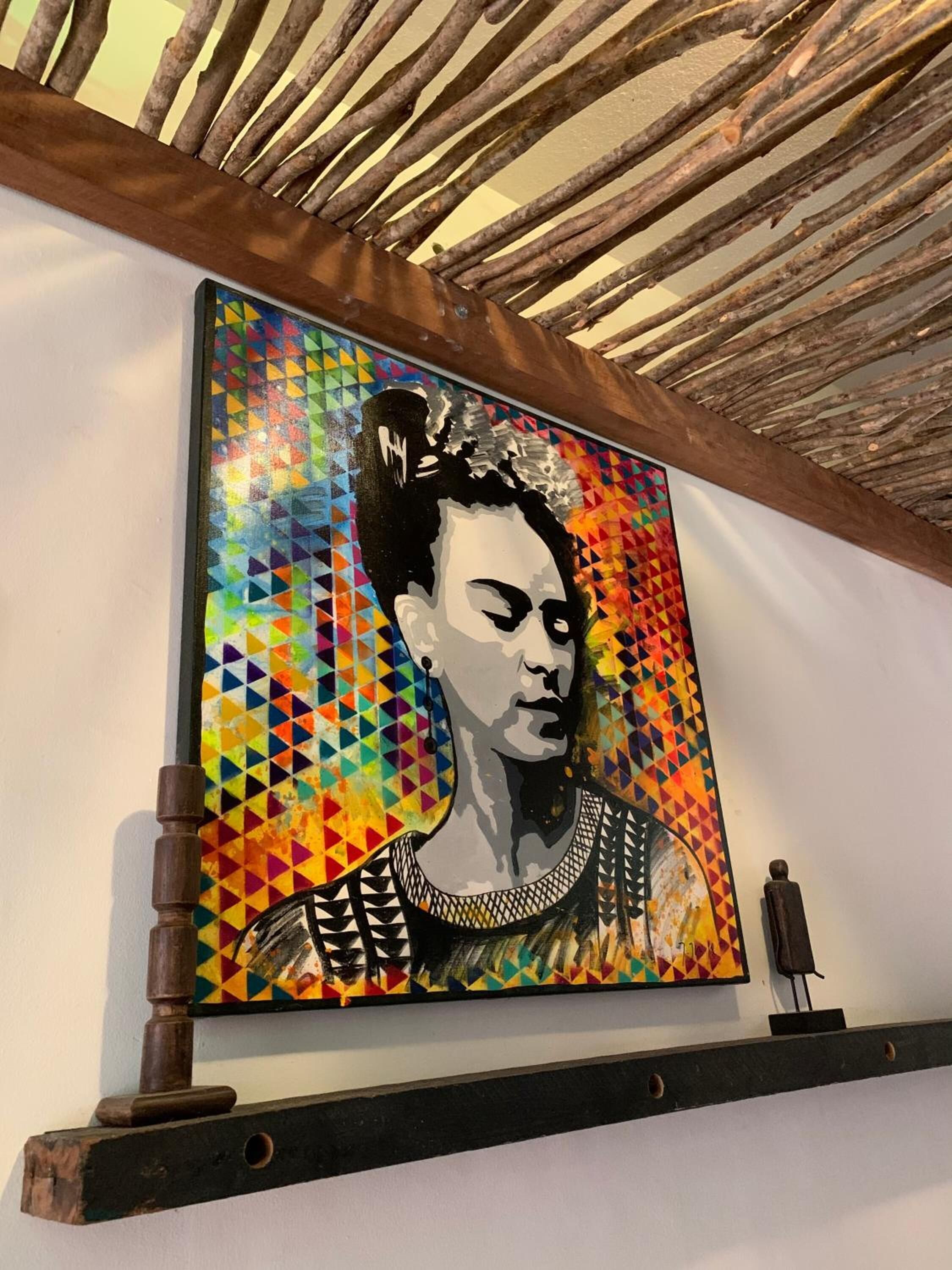 Uma pintura vibrante em estilo pop art numa parede, com teto de vigas de madeira.