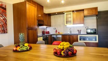 Apartamento premium, várias camas, vista para o pátio | Cozinha privada | Geladeira, micro-ondas, fogão, cooktop