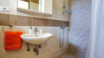 Apartamento premium, várias camas, vista para o pátio | Banheiro | Chuveiro, secador de cabelo, toalhas de banho, sabonete