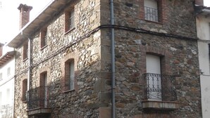 Um edifício de pedra com várias janelas e uma varanda.