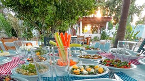 Uma mesa posta com diversos pratos, incluindo um peixe inteiro e vários tabuleiros de comida.