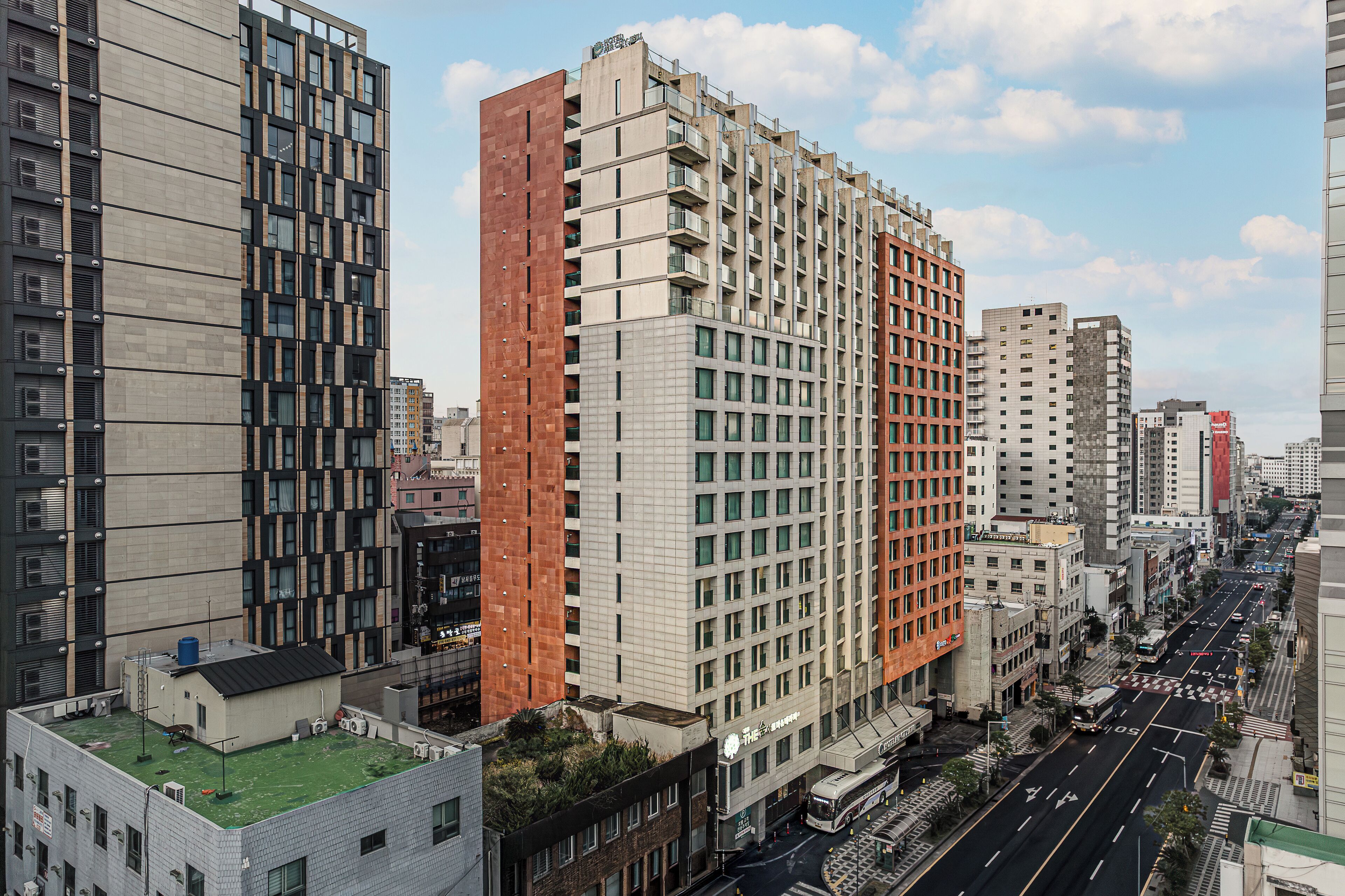 Um edifício alto com vários andares, janelas amplas e um terraço plano.