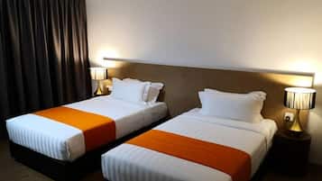 Duas camas de solteiro com roupa de cama branca e laranja, uma cabeceira marrom e abajures.