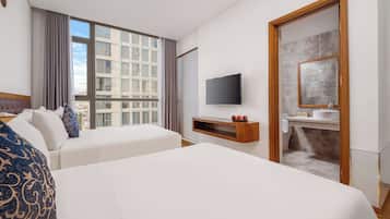 Quarto Triplo Deluxe | Minibar, secretária adequada para computadores portáteis