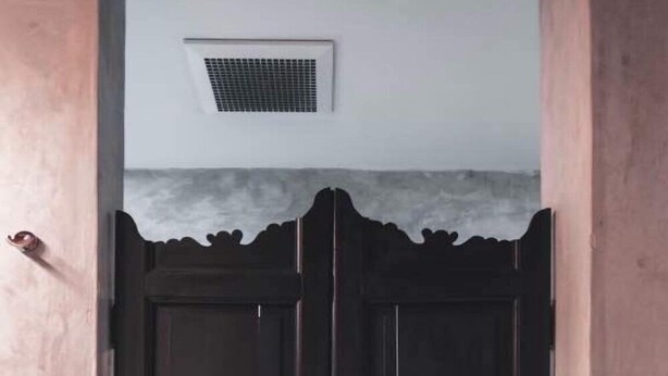 Uma porta dupla de madeira escura com puxadores elaborados e detalhes decorativos.
