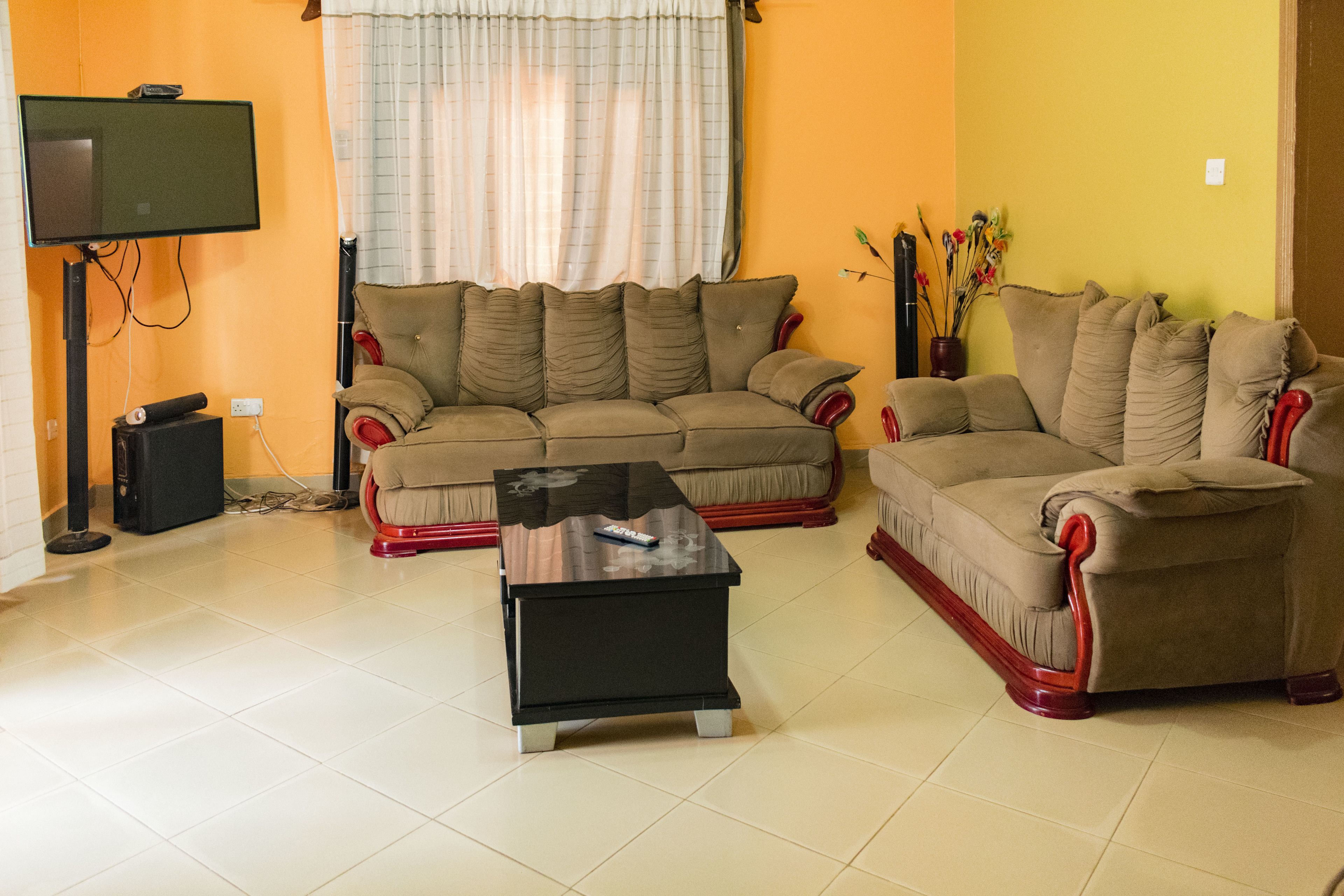 Uma sala de estar com dois sofás, uma mesa de centro, uma televisão e um alto-falante.