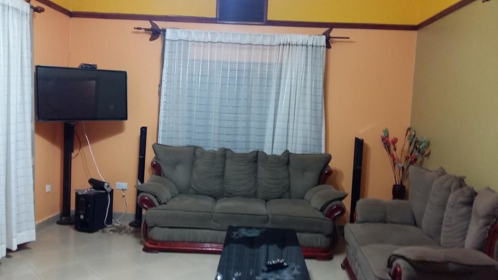 Sala de estar com dois sofás, uma televisão e uma mesa de centro.