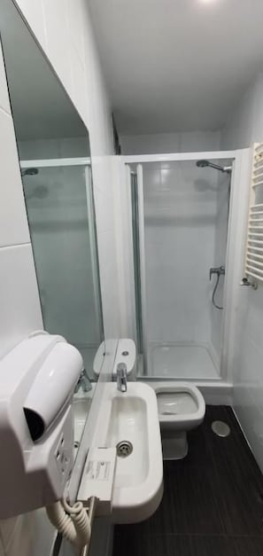 Casa de banho com lavatório, sanita e chuveiro.