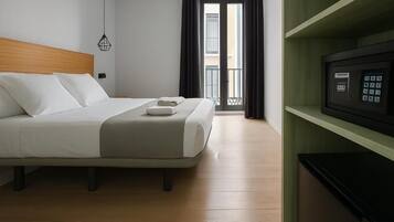 Quarto de hotel com cama, televisão e vista para o exterior.