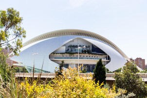 Um edifício moderno com telhado curvo e varanda.