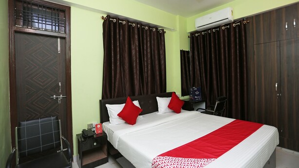 Quarto com cama, cadeira, mesa de cabeceira e guarda-roupa.