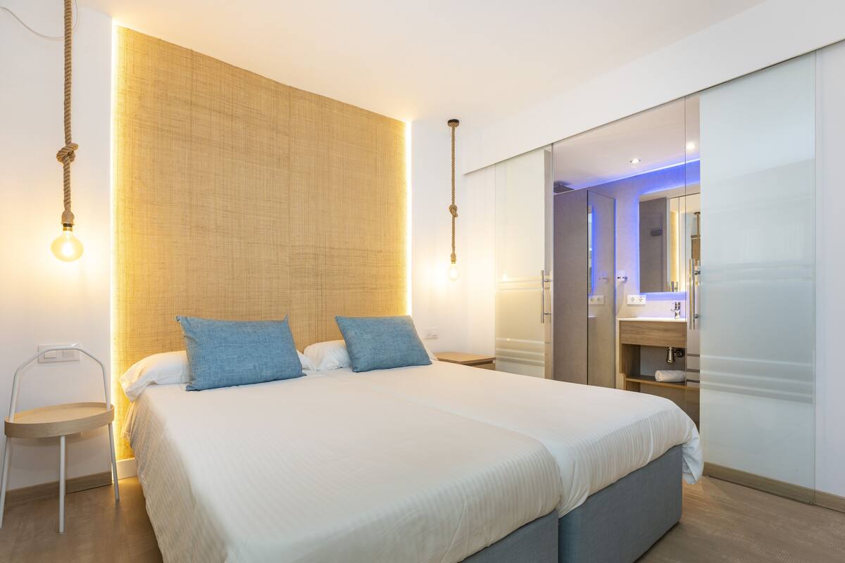 Um quarto moderno com uma cama grande, mesas de cabeceira e um closet espaçoso.