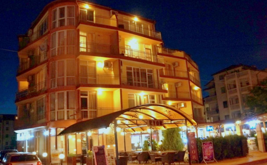 Um hotel com vários andares, varandas, área externa para sentar e entrada coberta.