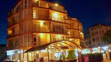 Um hotel com vários andares, varandas, área externa para sentar e entrada coberta.
