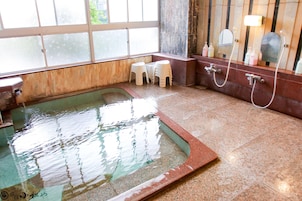 Casa de banho com uma piscina pequena, chuveiro e janela.