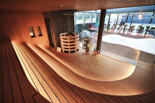 Um deck de madeira com borda curva, um lustre pendurado e vista para o exterior.