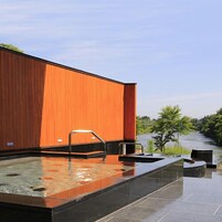 Uma área de spa moderna com hidromassagem, uma piscina pequena e vista para o rio.