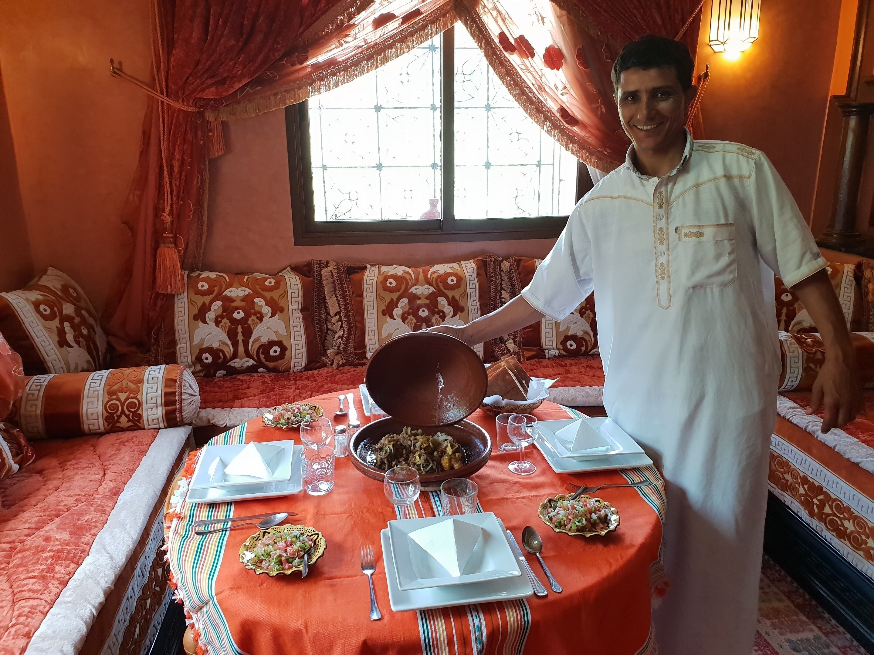 Uma sala de jantar com uma mesa posta para dois, apresentando uma refeição tradicional e uma decoração elegante.