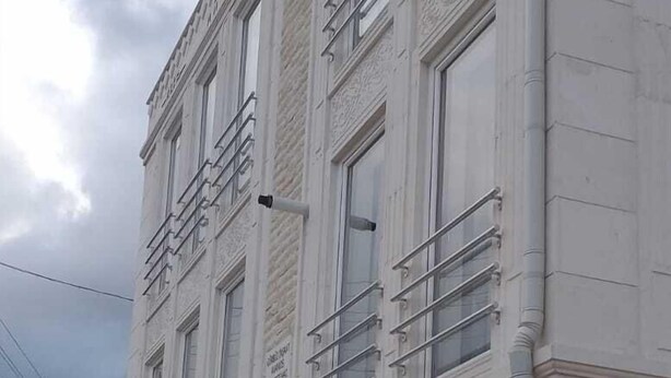 Um edifício branco com grandes janelas e molduras decorativas.