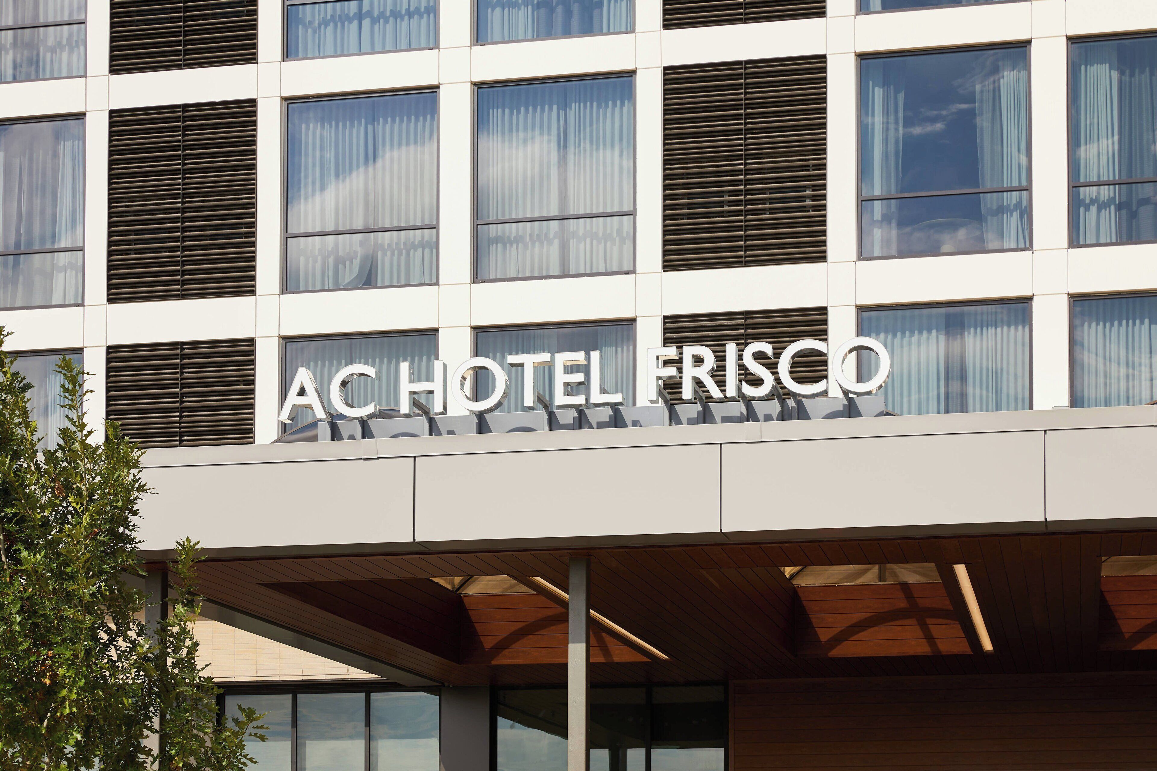 Fachada moderna de hotel com o nome "AC HOTEL FRISCO" em destaque.