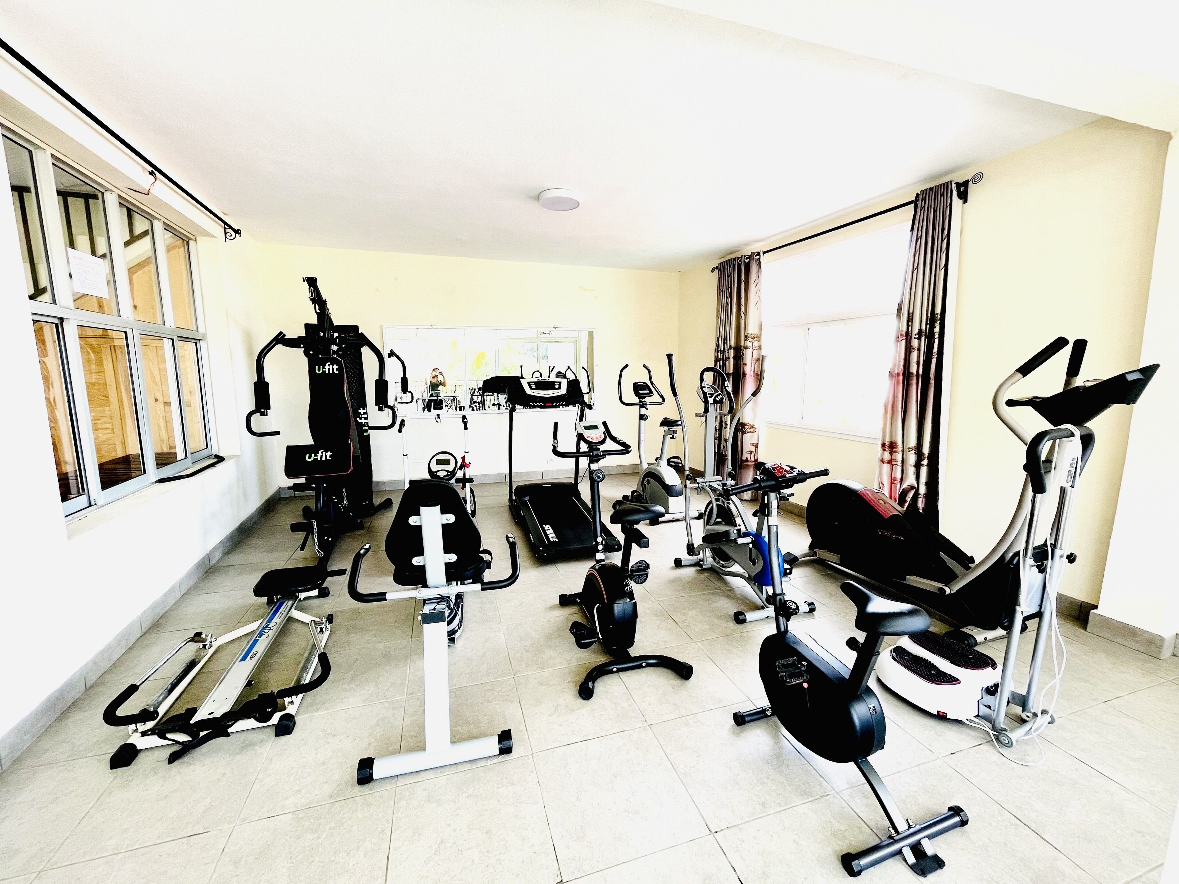 Academia com diversos equipamentos de ginástica, incluindo esteiras, bicicletas ergométricas e elípticos.