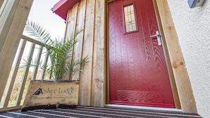 Um edifício de madeira com uma porta vermelha e uma placa que diz 'Skye Lodge'.