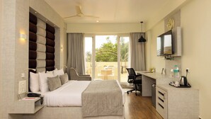 Quarto de hotel moderno com uma cama grande, uma escrivaninha, uma cadeira e vista para o exterior.