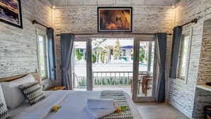 Um quarto espaçoso com uma cama grande, vista para o exterior e um quadro na parede.