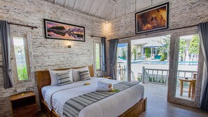 Quarto espaçoso com uma cama grande, cabeceira de madeira e vista para a área da piscina.