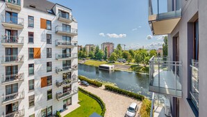 Um edifício moderno com apartamentos e diversas varandas com vista para o rio.