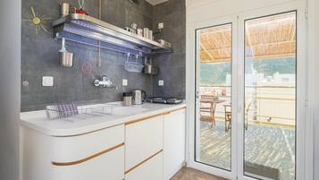 Apartamento Panorâmico | Kitchenette privada | Um frigorífico, uma placa de cozinha, uma máquina de café expresso