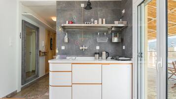 Apartamento Panorâmico | Kitchenette privada | Um frigorífico, uma placa de cozinha, uma máquina de café expresso