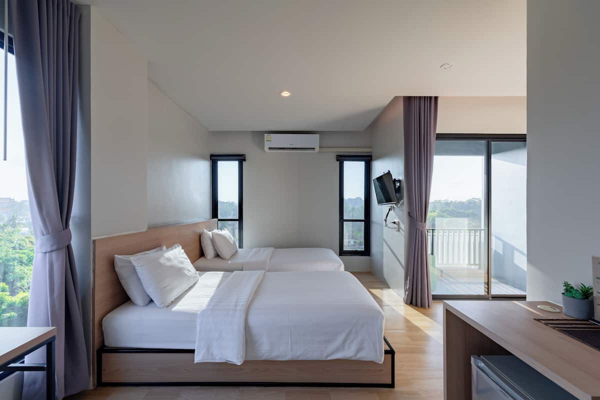 Um quarto moderno com cama, mesas de cabeceira, ar condicionado e vista para o exterior.